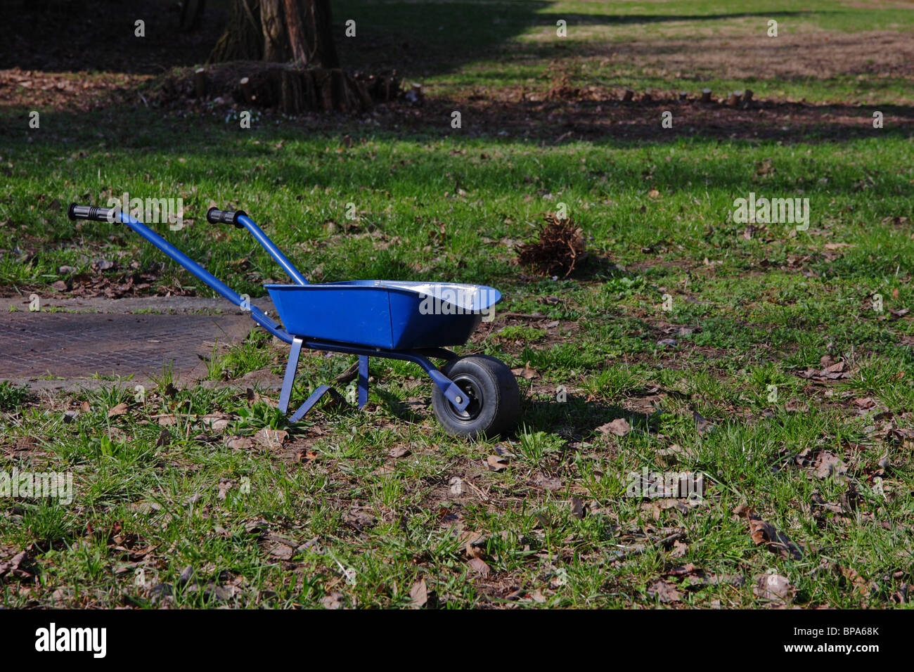 Blue iron wheelbarrow in grass Stock Photo - Alamy