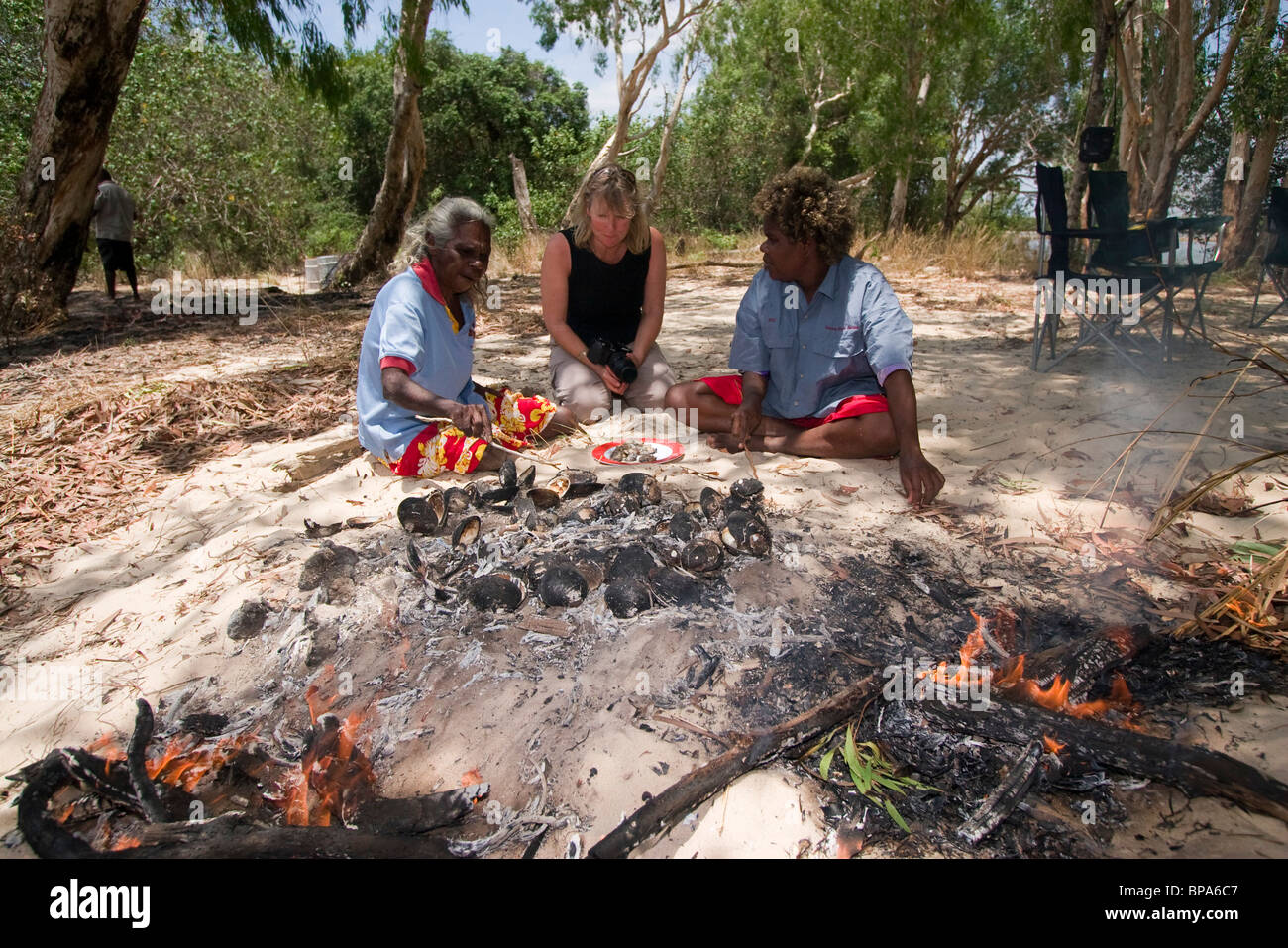 A tourist and two aboriginal women from the MV Pikkuw sit around a ...