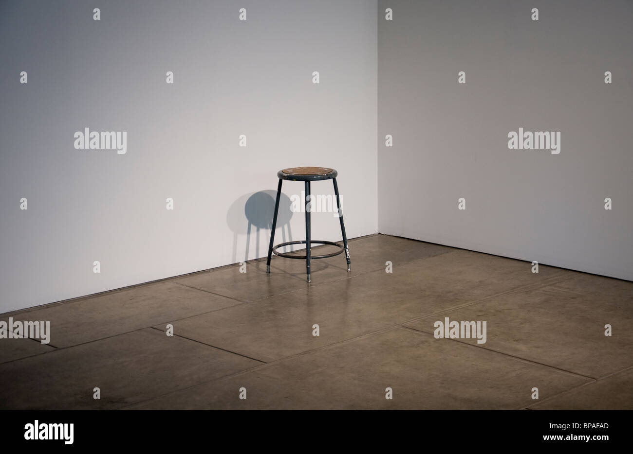 A lone stool in the corner of an empty room Stock Photo - Alamy