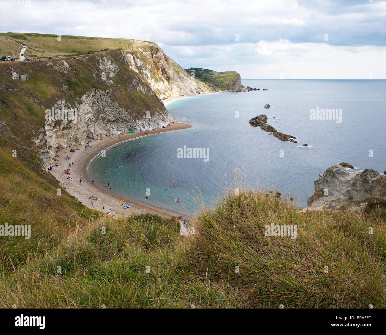 Sunlit curved beach inlet near Durdle Door, Weymouth, Dorset, UK Stock ...