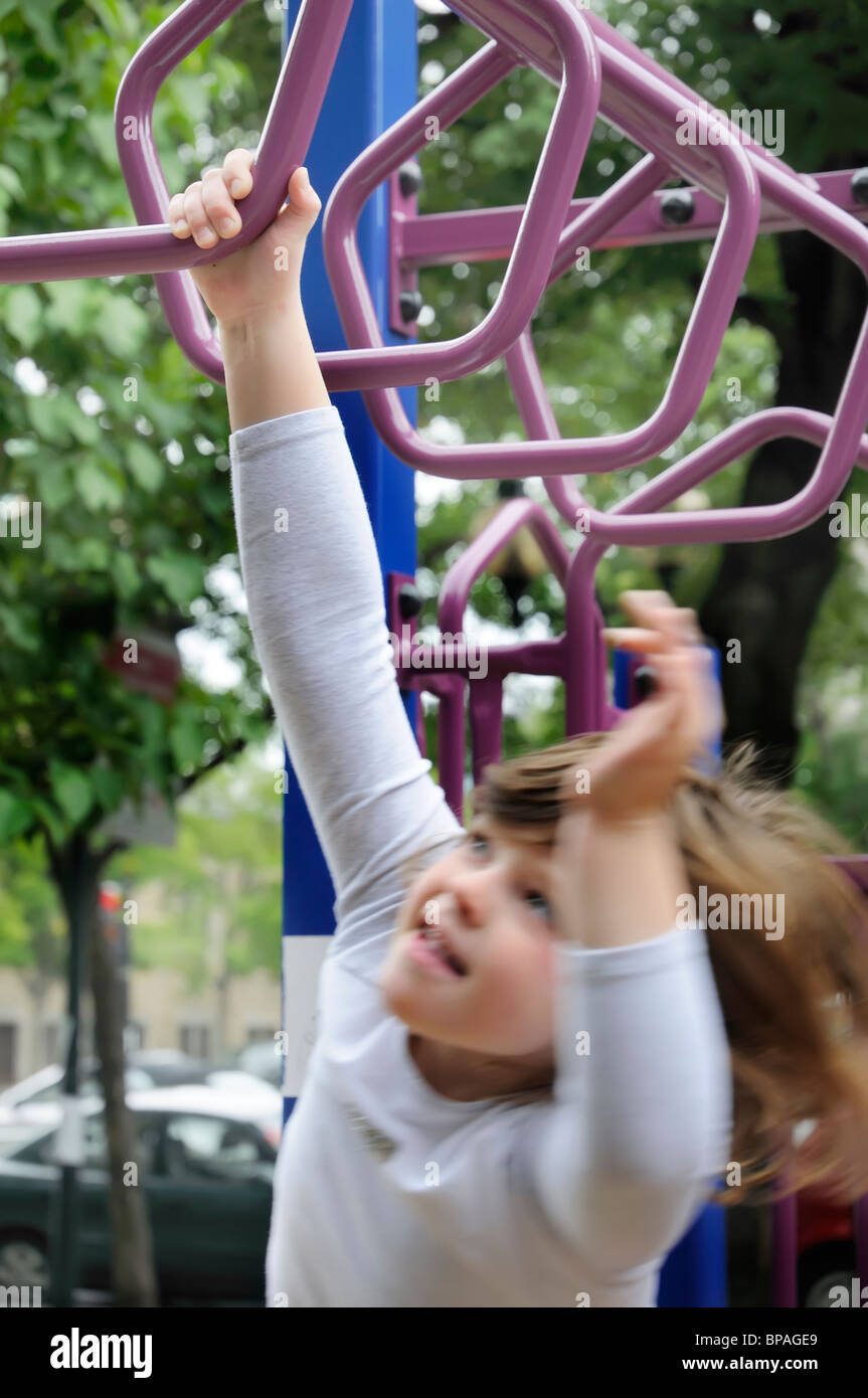 Young girl playing on a climbing frame Stock Photo - Alamy