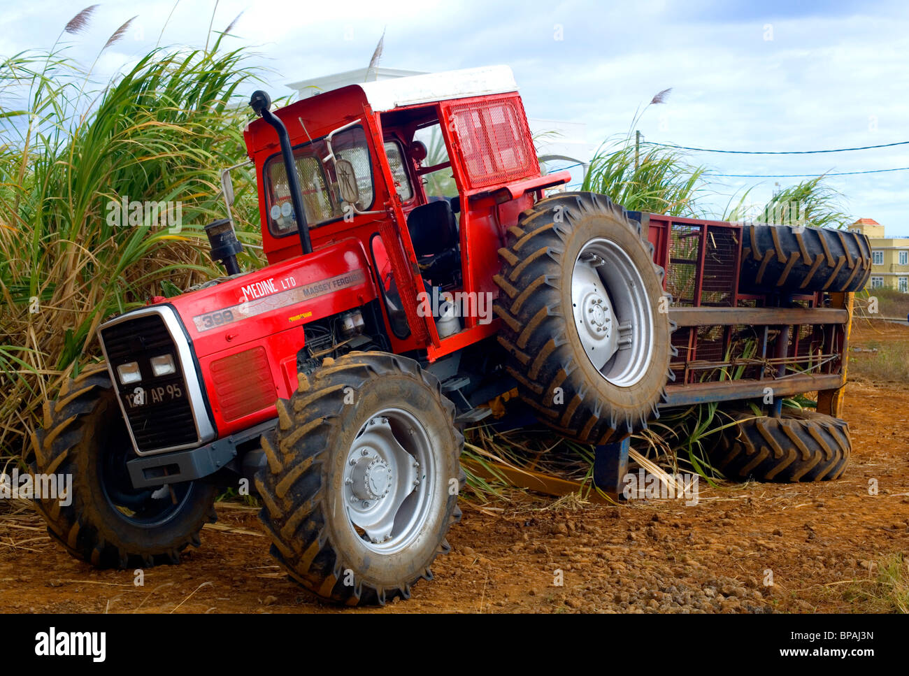 Red farming tractor with accidental overturned trailer hi-res stock ...
