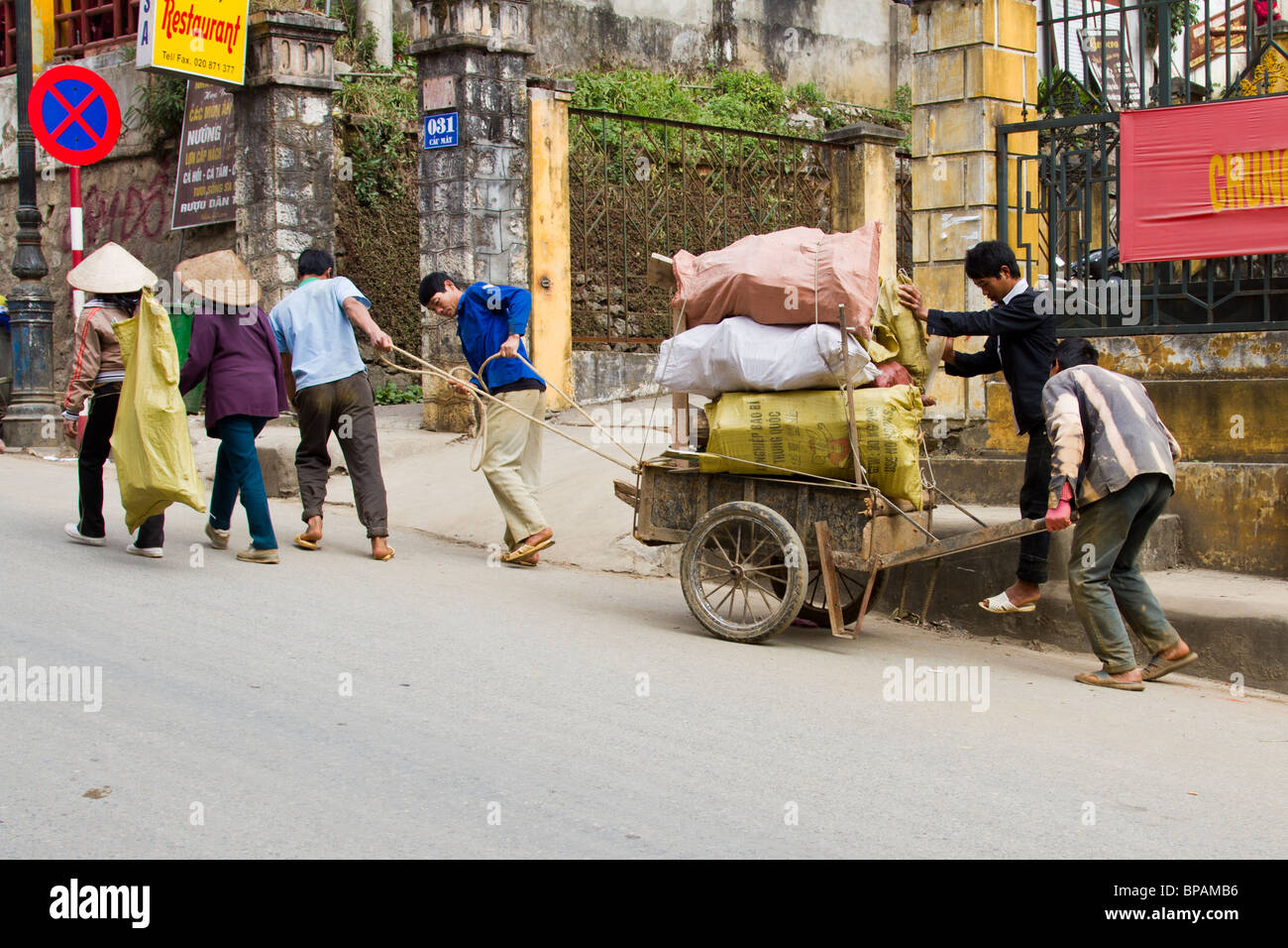 Vietnamese men push and pull a cart up the street in Sapa vietnam Stock ...