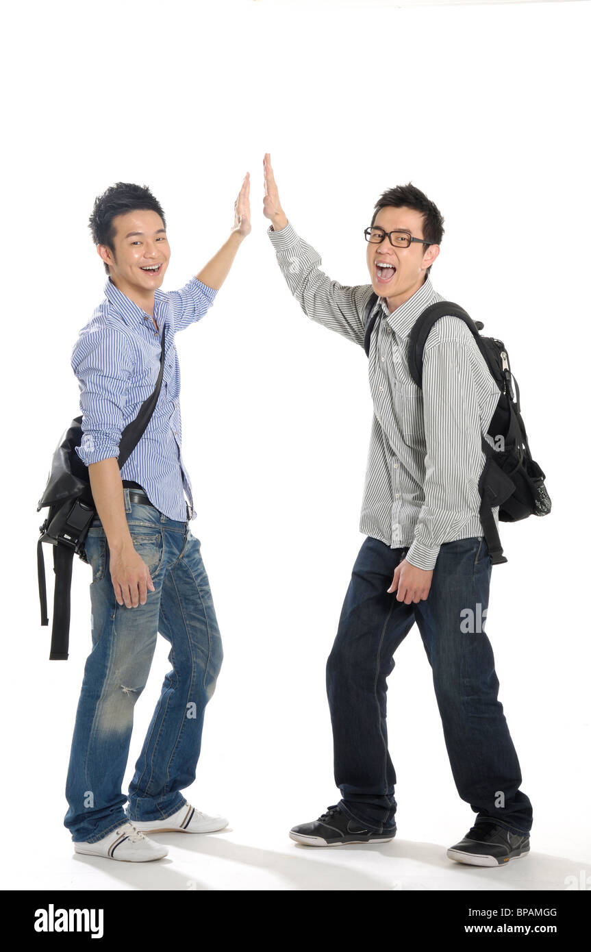 Male university students giving high-five to each other Stock Photo - Alamy