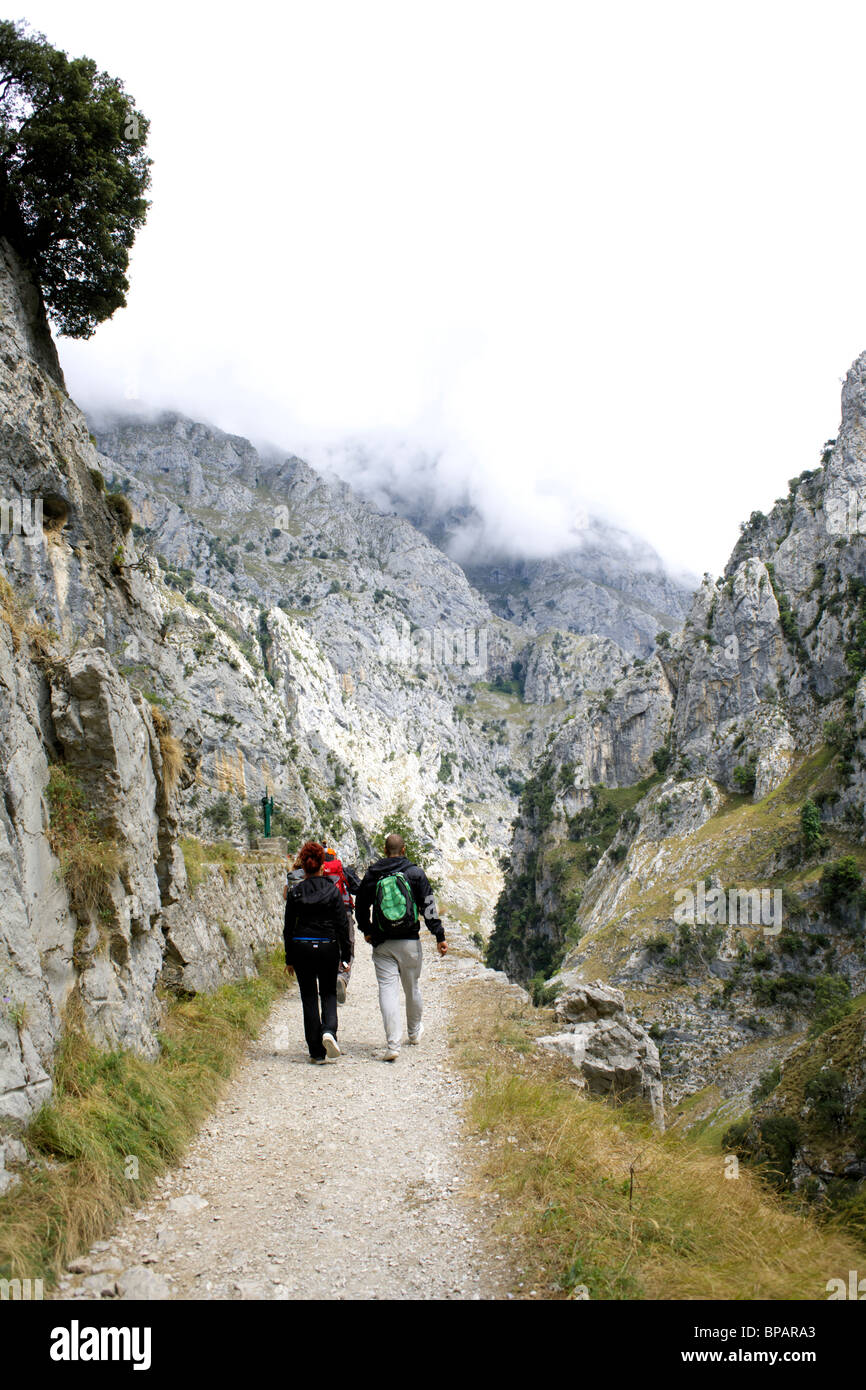 Walkers head up into the clouds on a dull day, the Cares Route, along ...