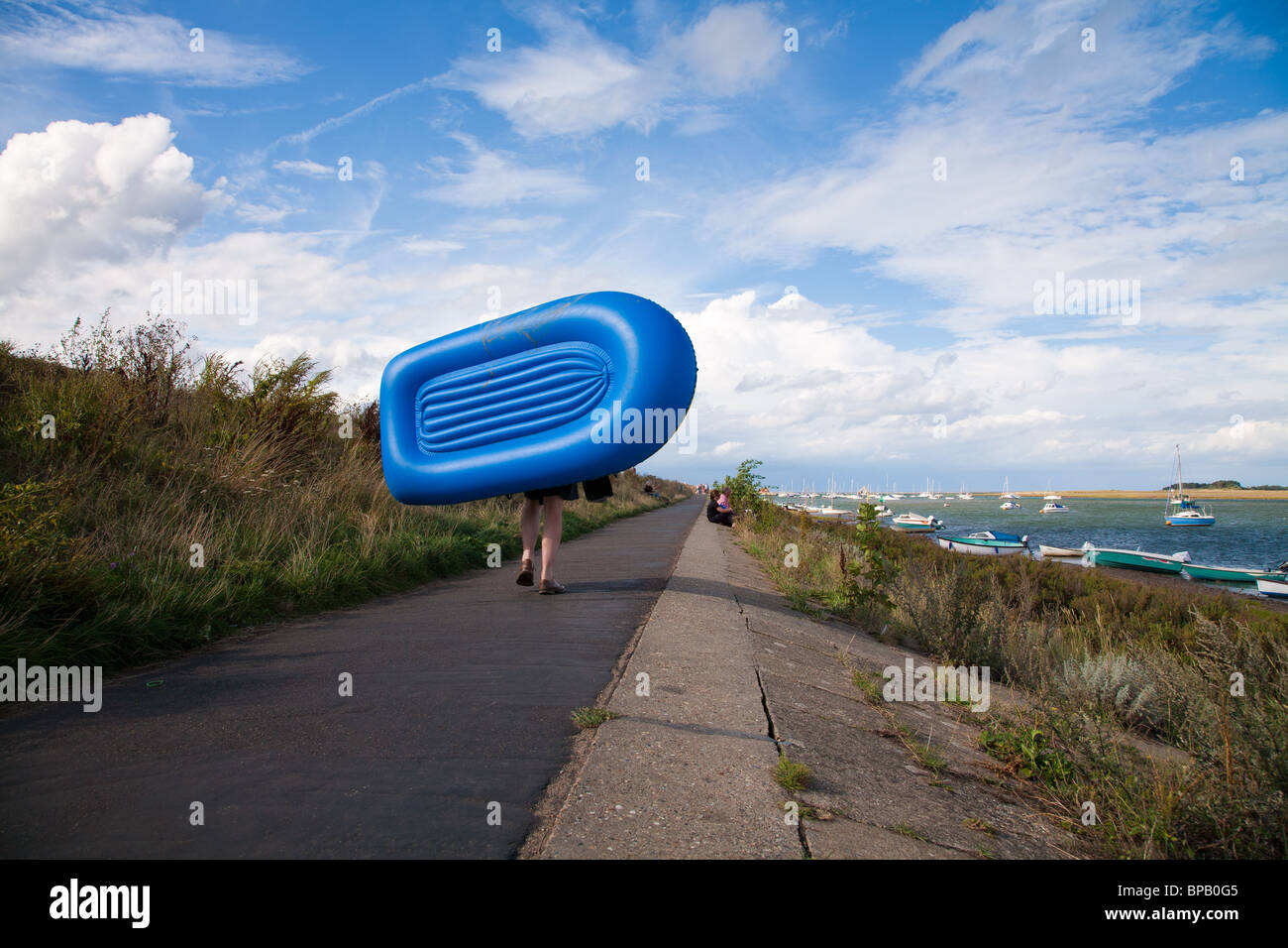 blue inflatable boat carried along path by sea Stock Photo - Alamy