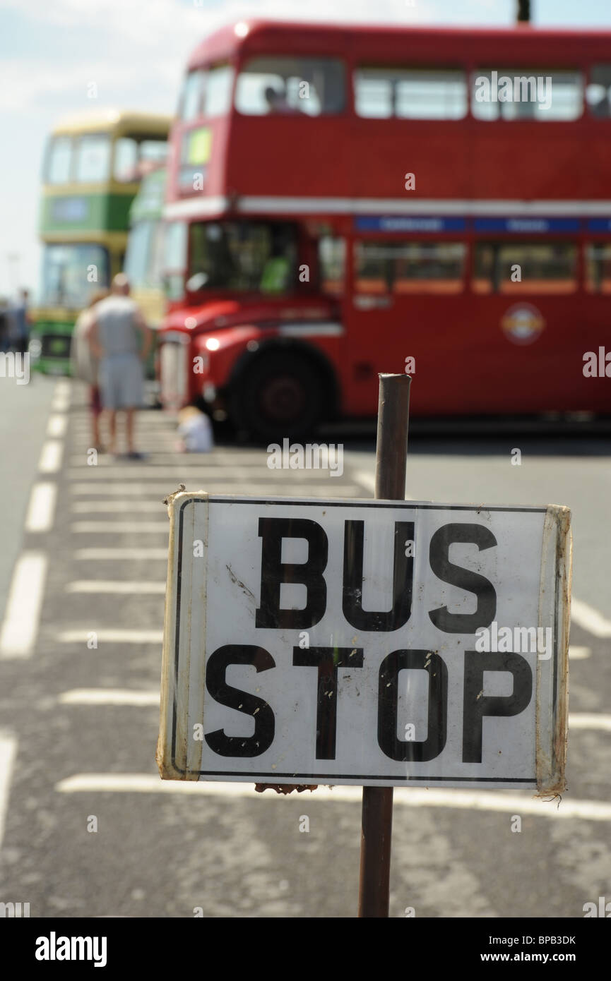 Bus Stop sign and bus in the background Stock Photo - Alamy