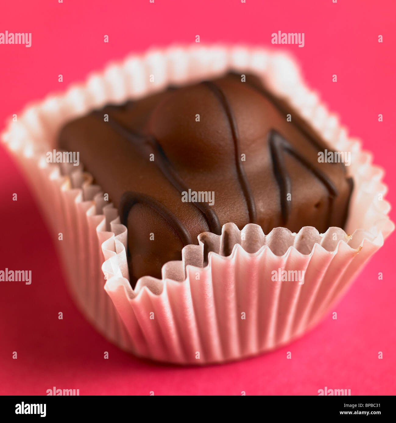 Chocolate Fondant Fancy On A Pink Background Closeup Stock Photo - Alamy