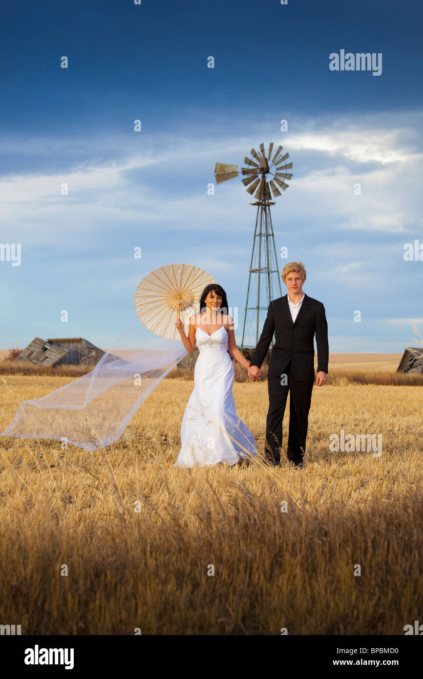 three hills, alberta, canada; a bride and groom posing in a farm field ...