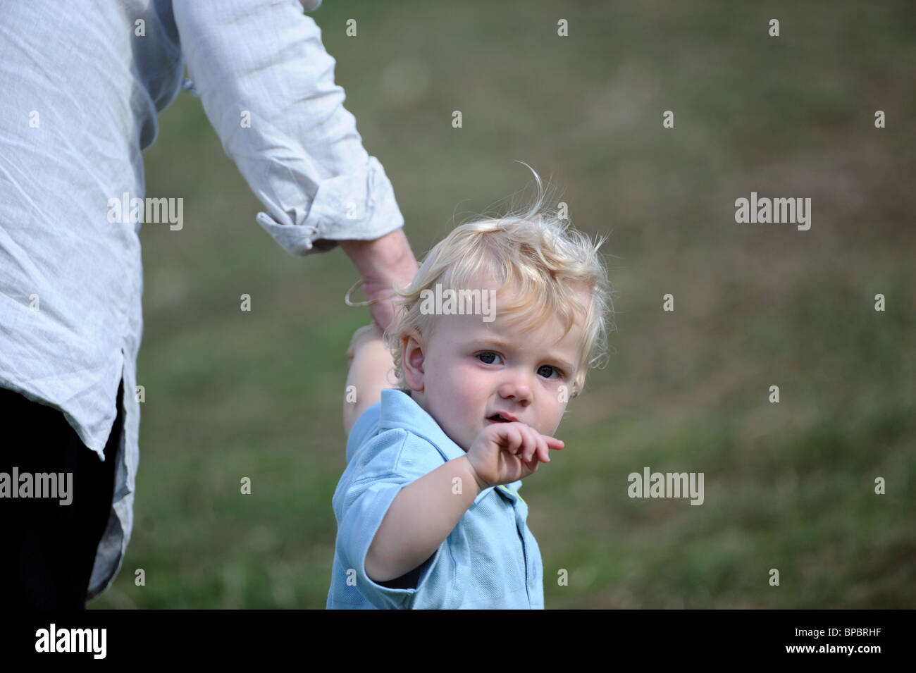 A toddler looks back as he led away Stock Photo - Alamy