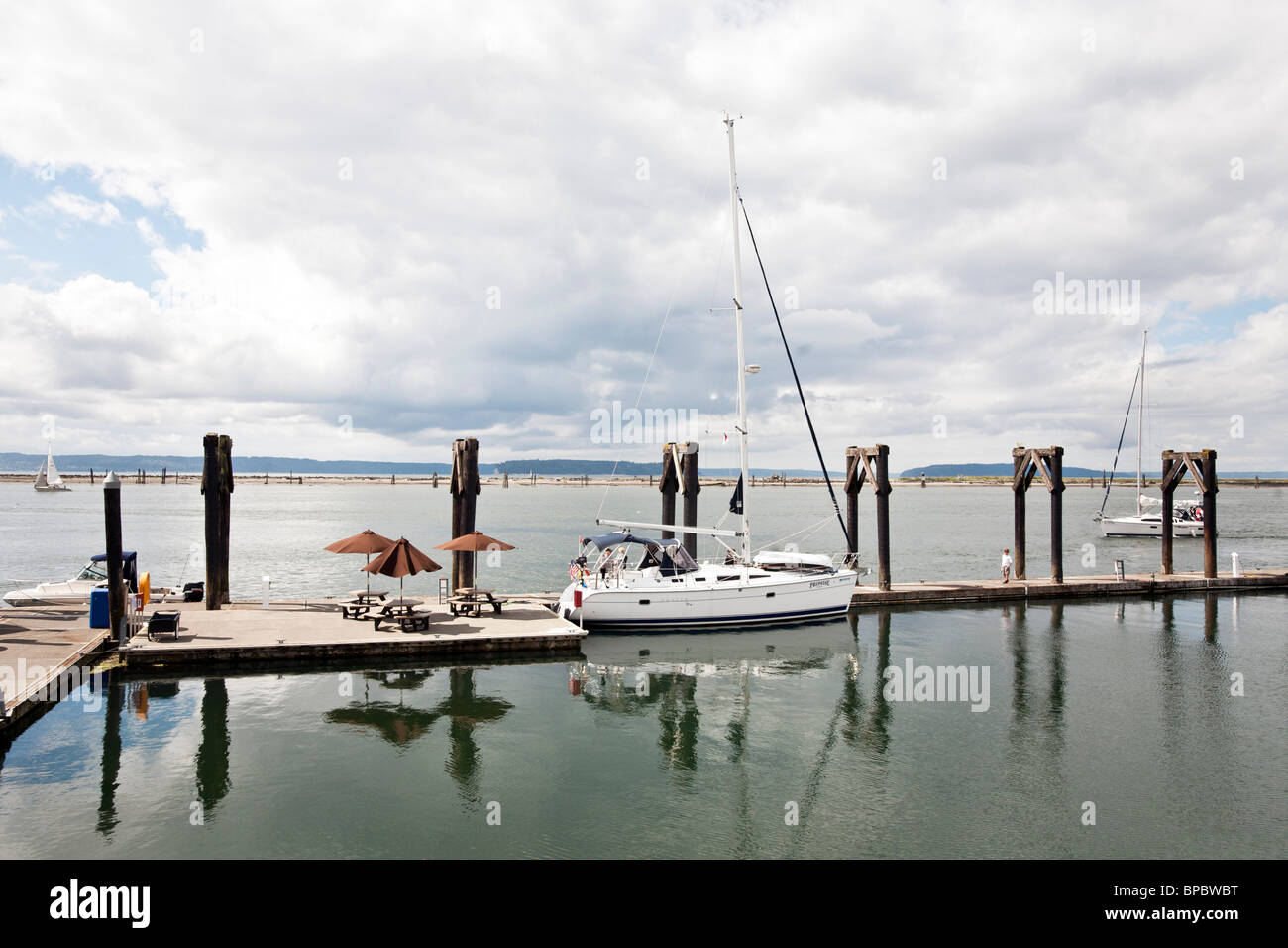 idyllic view of sailboat at temporary mooring, & dockside picnic tables ...