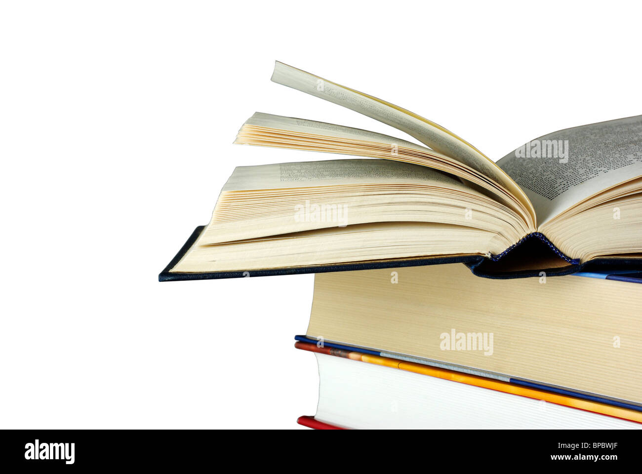 Opened book laying on other books isolated on white. Clipping path ...