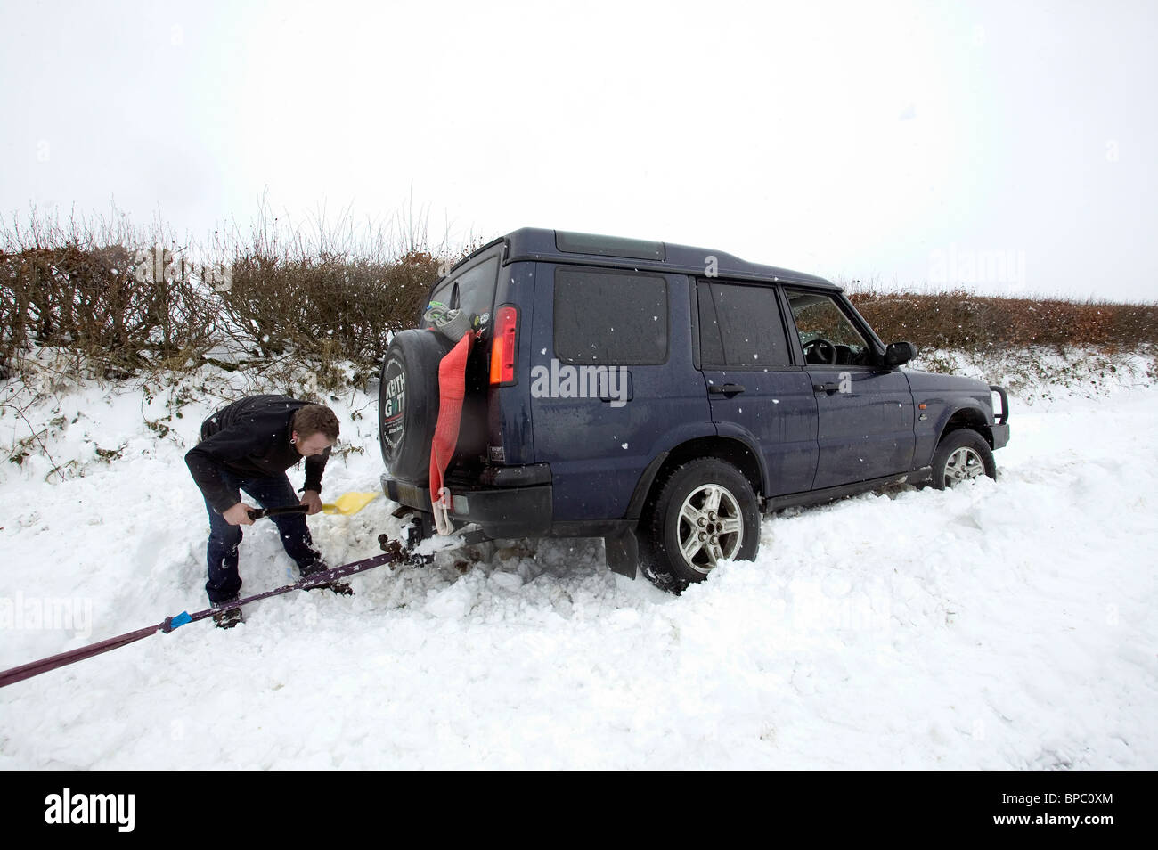 Man digging out snowed in four-wheel drive, Dartmoor, Devon Stock Photo ...