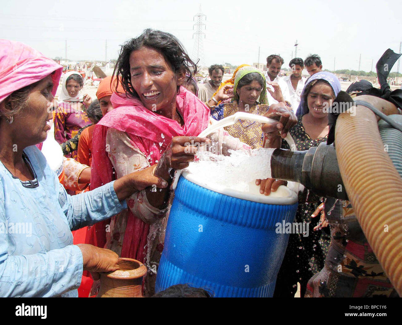 Flood affected women fill their water pots at a drinking water-tank at ...