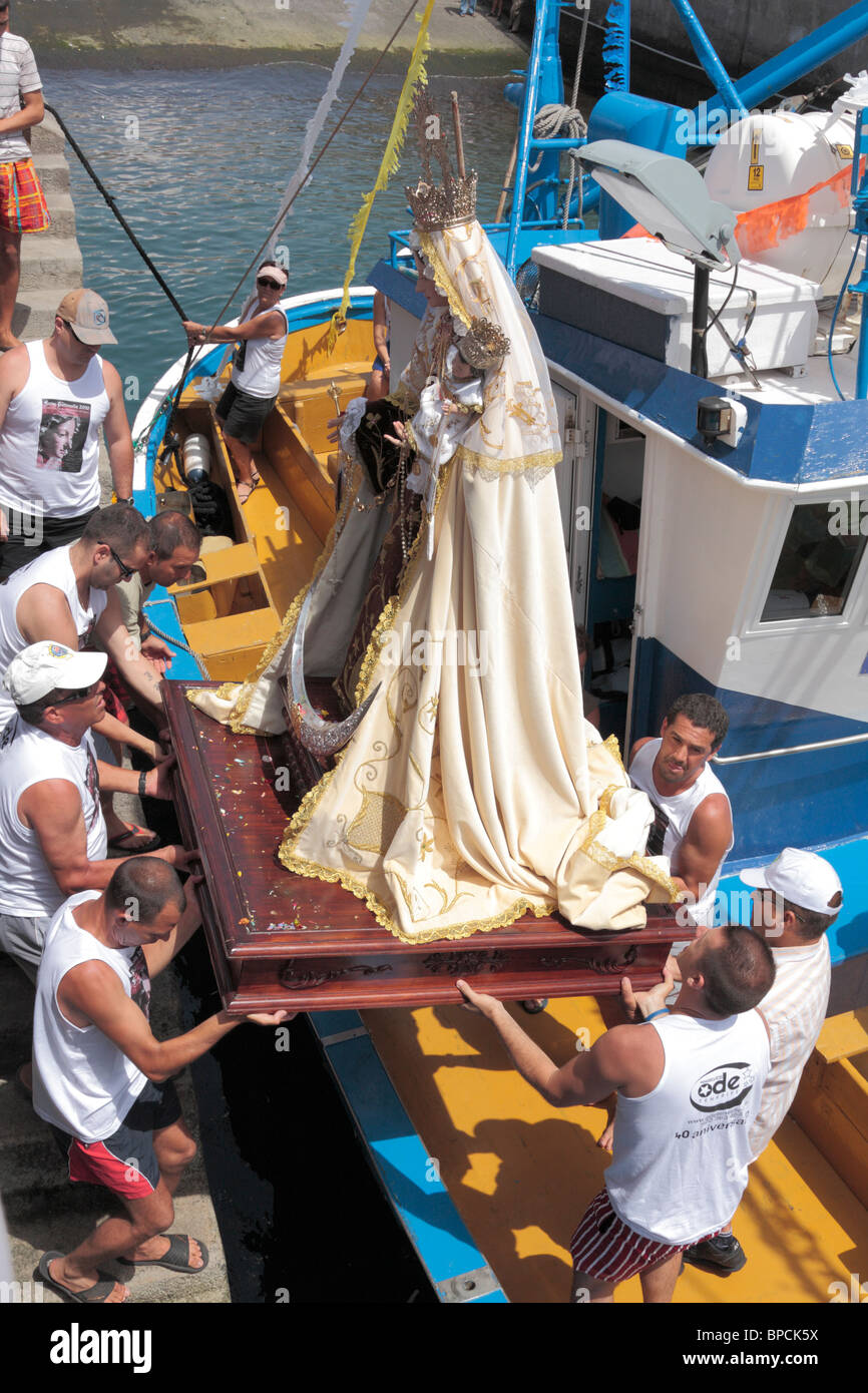 The Madonna or Senora de Carmen is lifted onto a fishing boat for the ...