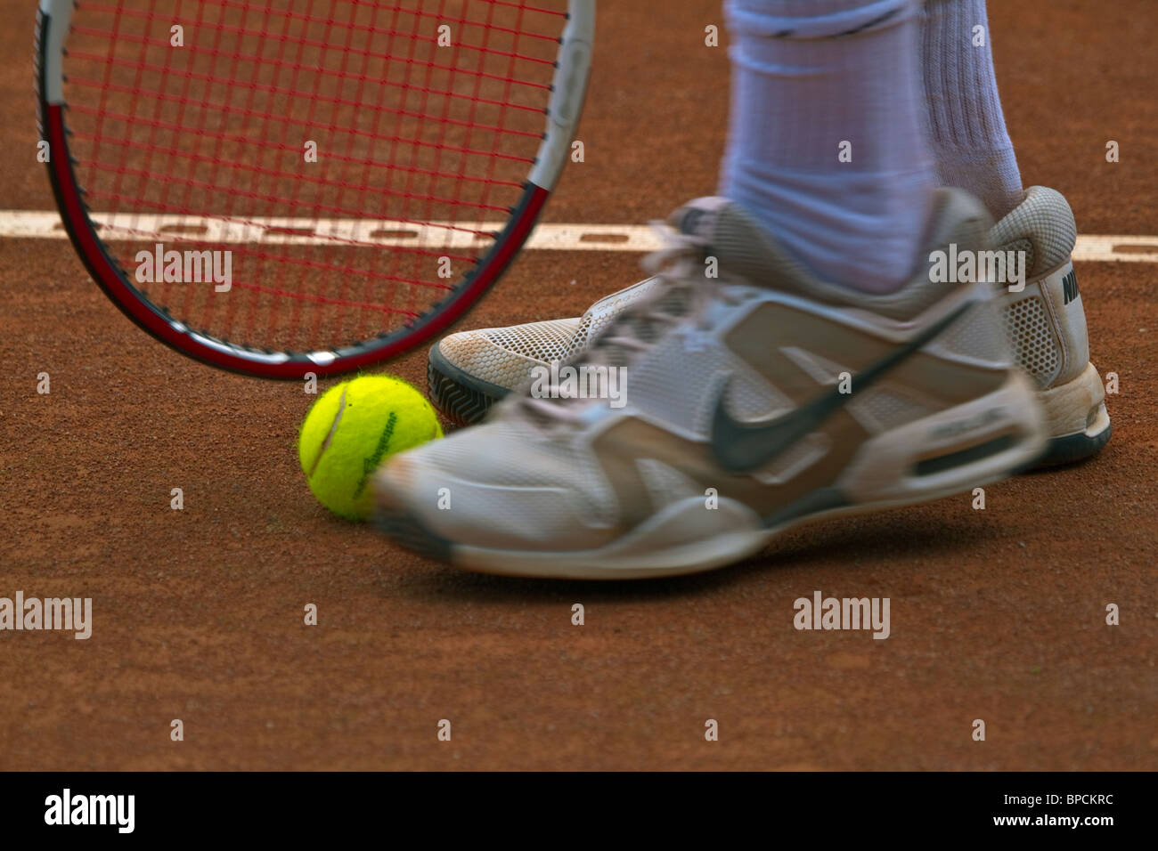 Clay court. Close-up of feet of tennis player skillful picking up the ...