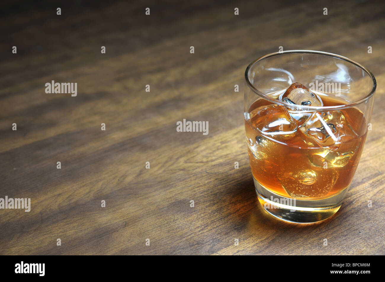 Bourbon on the rocks on wooden table with copy space Stock Photo - Alamy