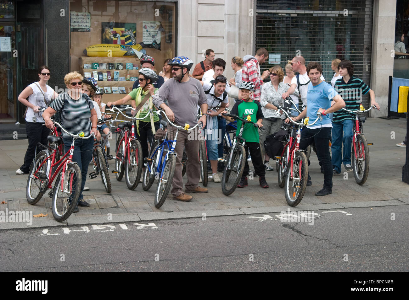 cyclists wait road crossing group summer safety Stock Photo - Alamy