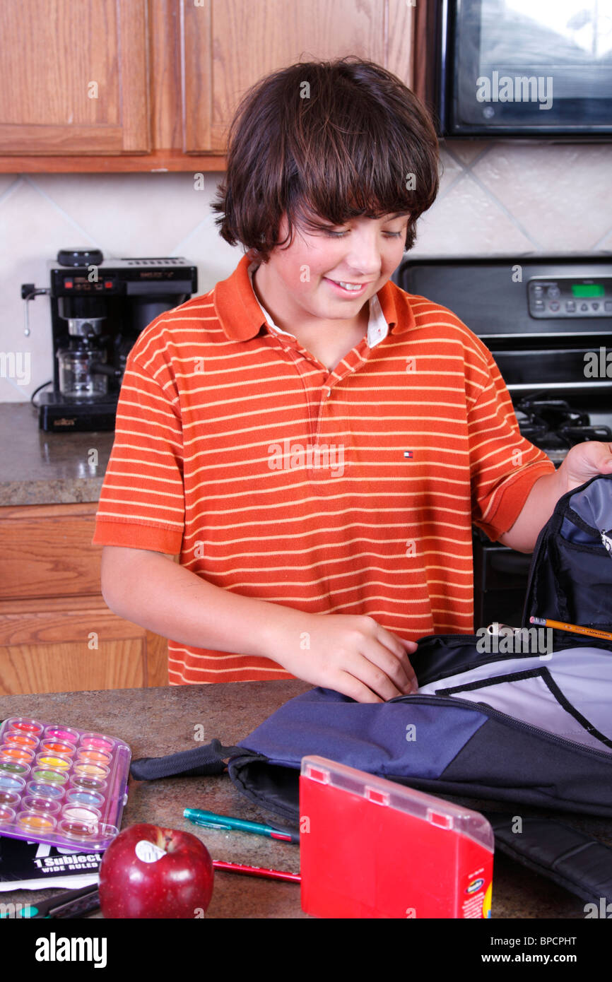 Student putting school supplies into backpack for school Stock Photo ...