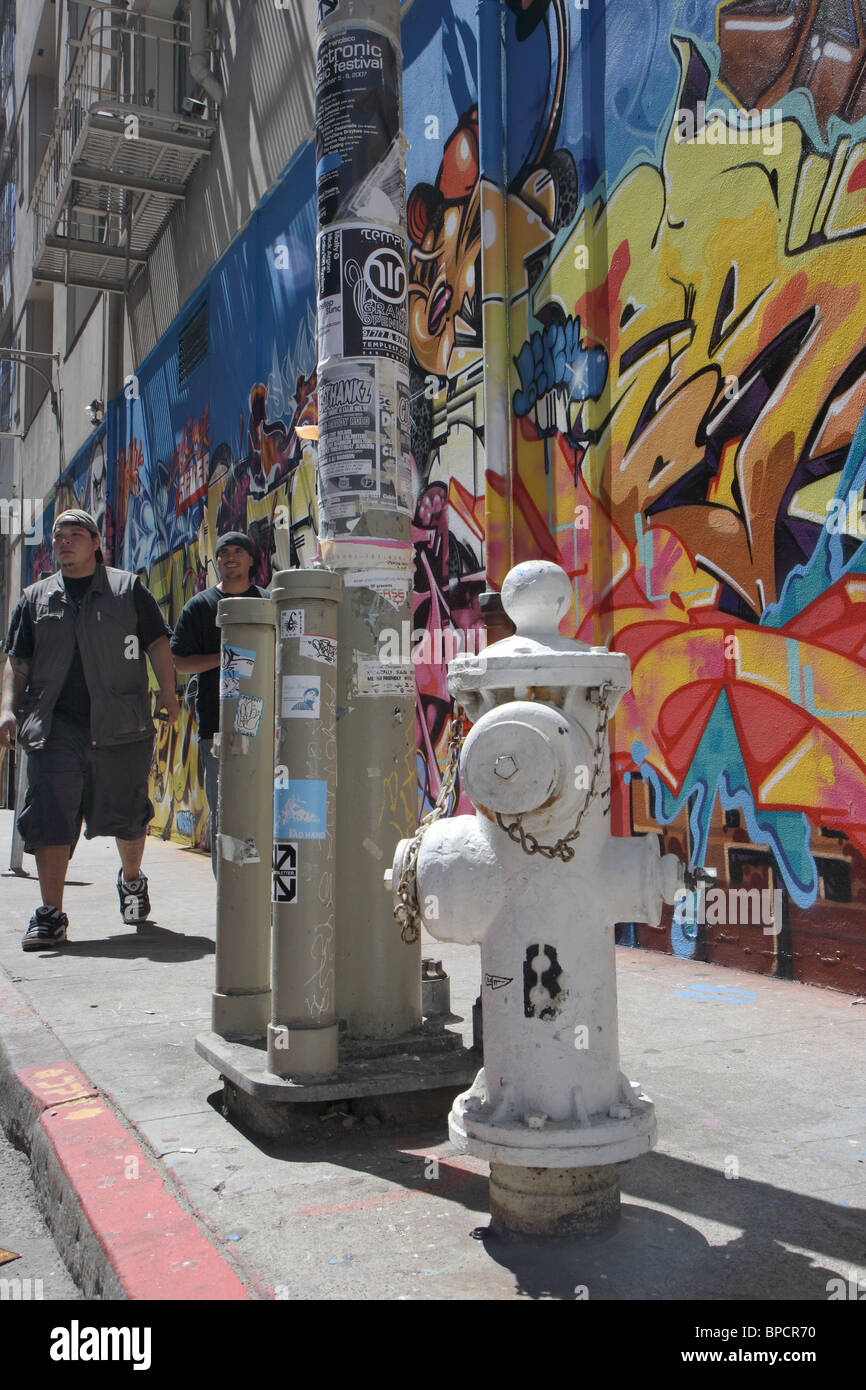 A fire hydrant in front of a wall decorated with colorful graffiti, San ...