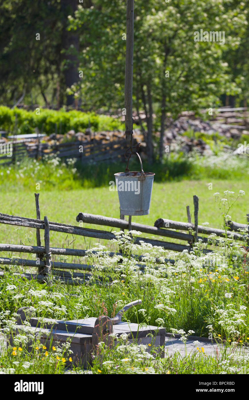 Tin bucket hanging above the water well Stock Photo - Alamy