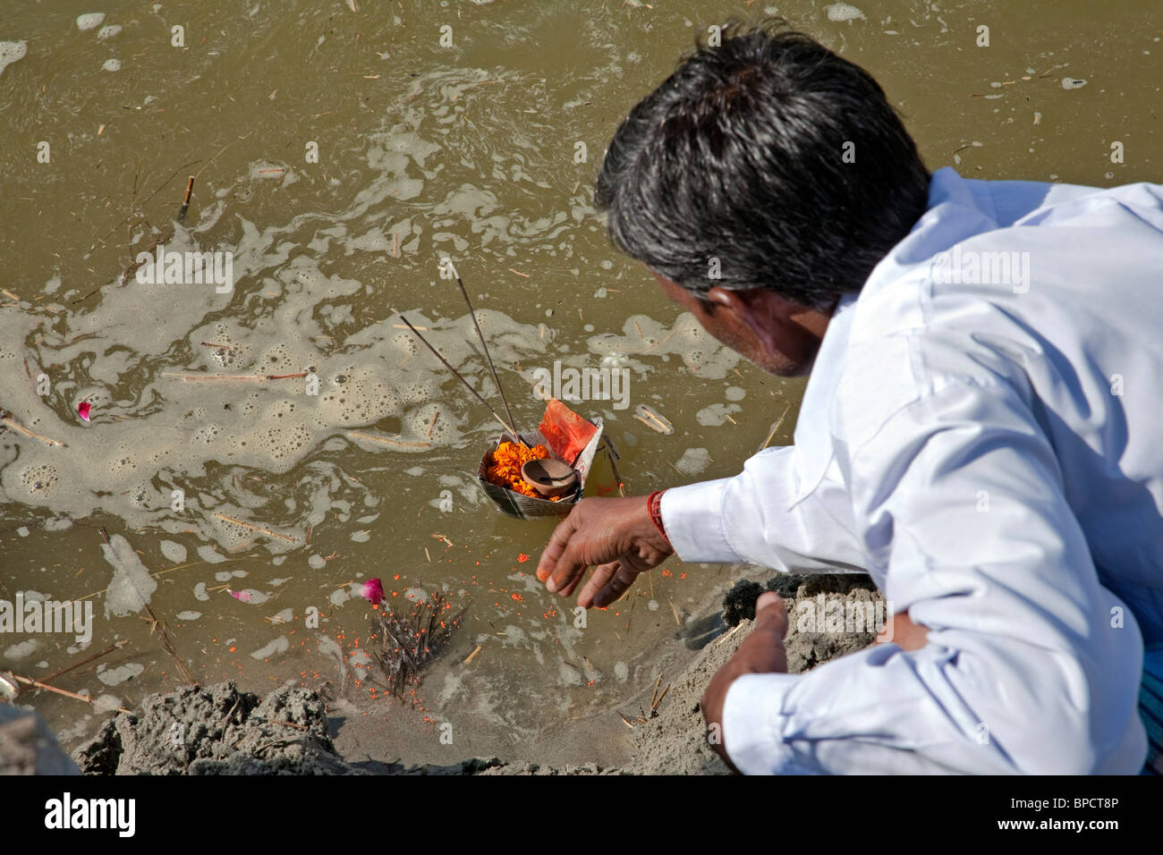 Indian man making a ritual offering. Ganges river. Varanasi. India ...
