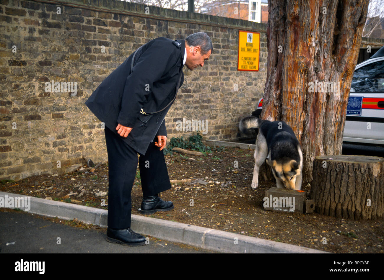 Policeman & Dog Dog Sniffing Suspicious Package Stock Photo - Alamy