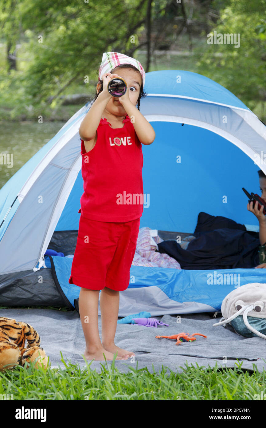 Cute girl looking at camera through telescope Stock Photo - Alamy