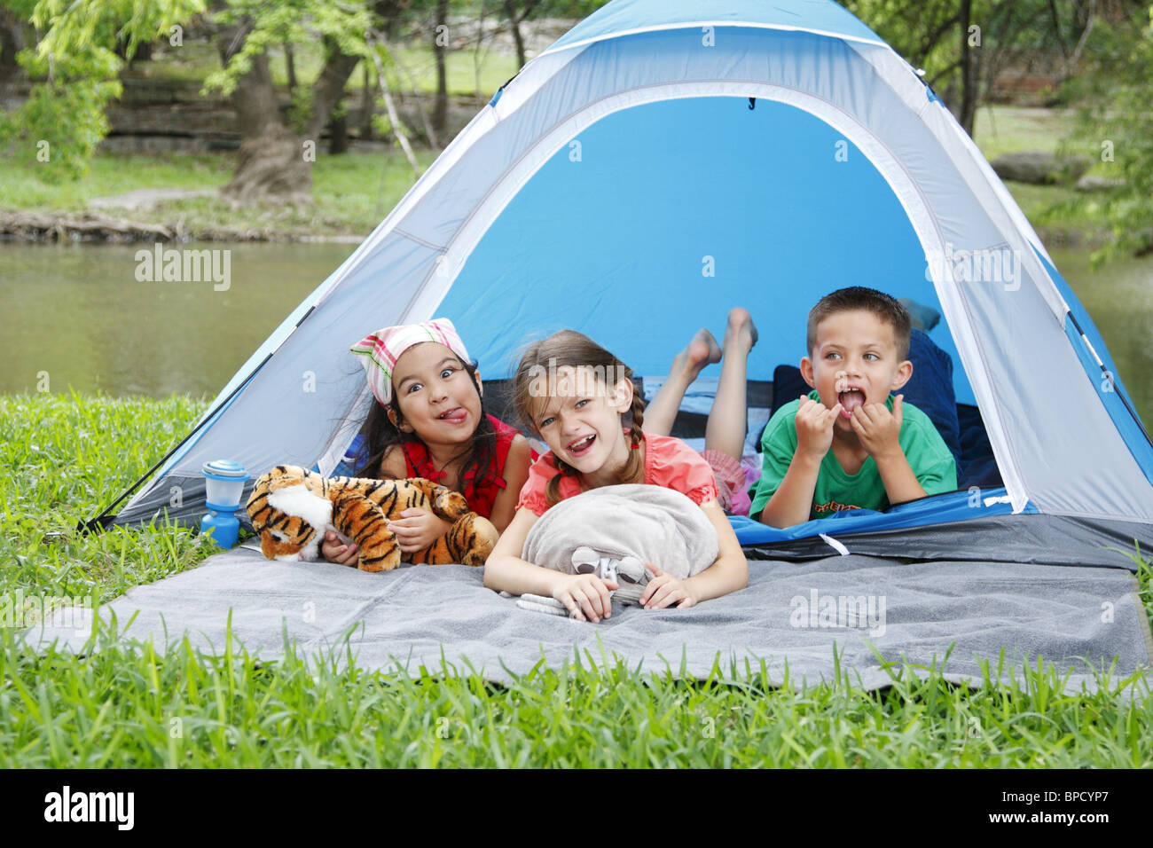 Kids in a tent acting goofy Stock Photo - Alamy