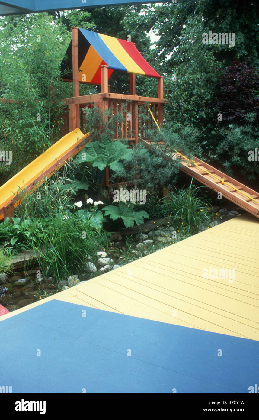 Child's backyard tree house, with slide, ramp, colorful blue and yellow ...