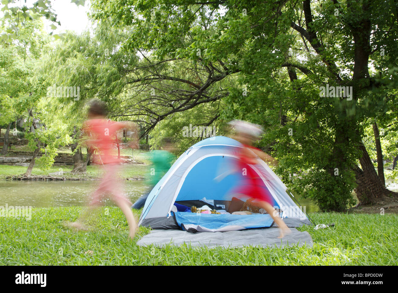 Kids chasing each other around a tent while camping Stock Photo - Alamy