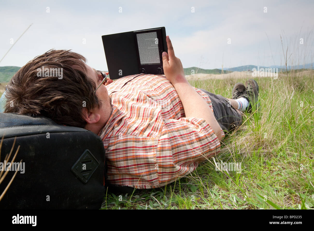 Guy Laying On The Grass And Reading A Book Stock Photo - Alamy
