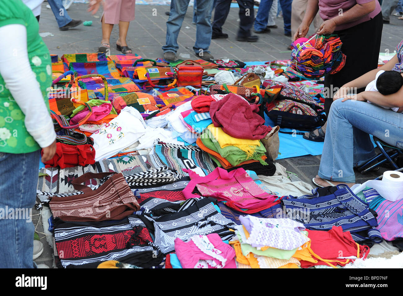 Brightly colored clothes displayed in busy market stall. Oaxaca, Mexico ...