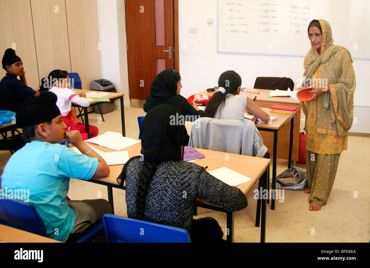 A female teacher taking a Punjabi lesson in Hounslow gurdwara, England ...