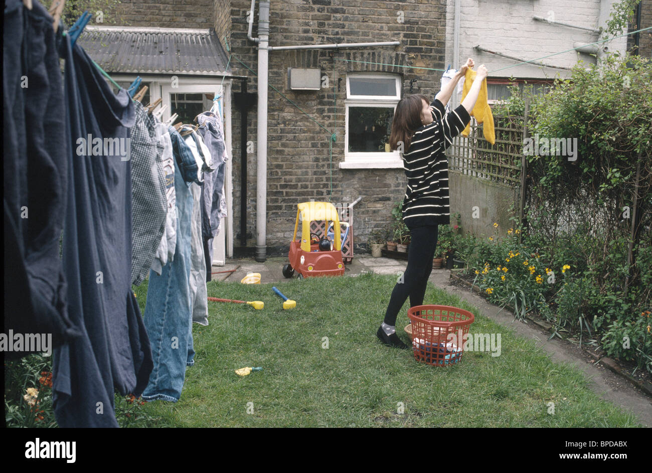 mother hanging the wash out on the line in the yard Stock Photo - Alamy