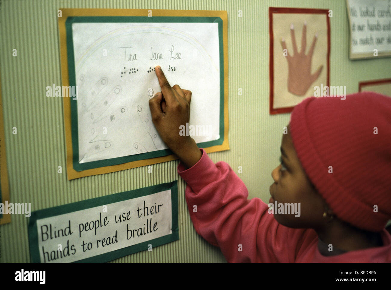 primary school girl reading braille from display board Stock Photo - Alamy