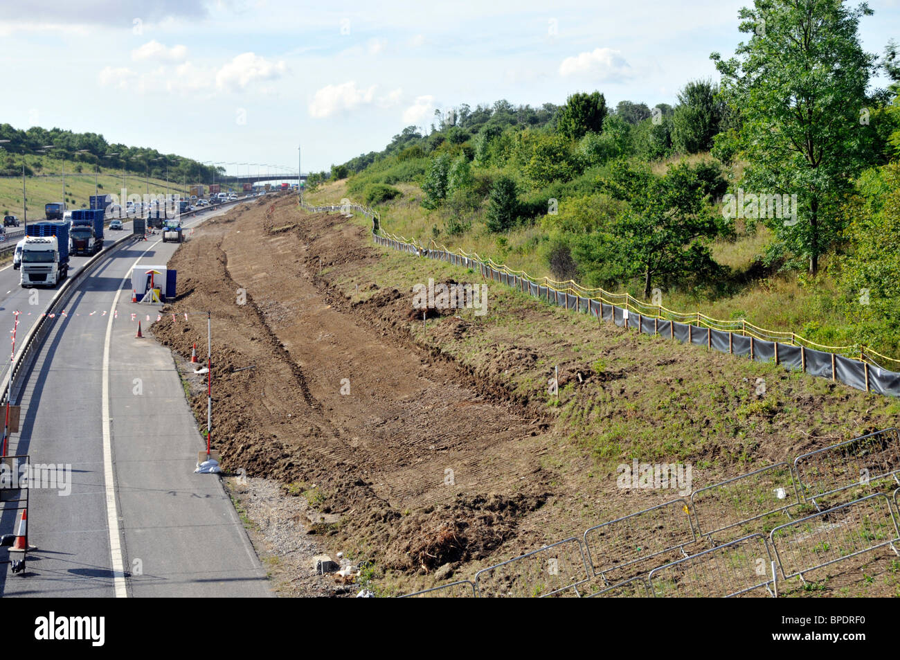 Plastic Newt reptile fencing erected on grass embankment for M25 ...