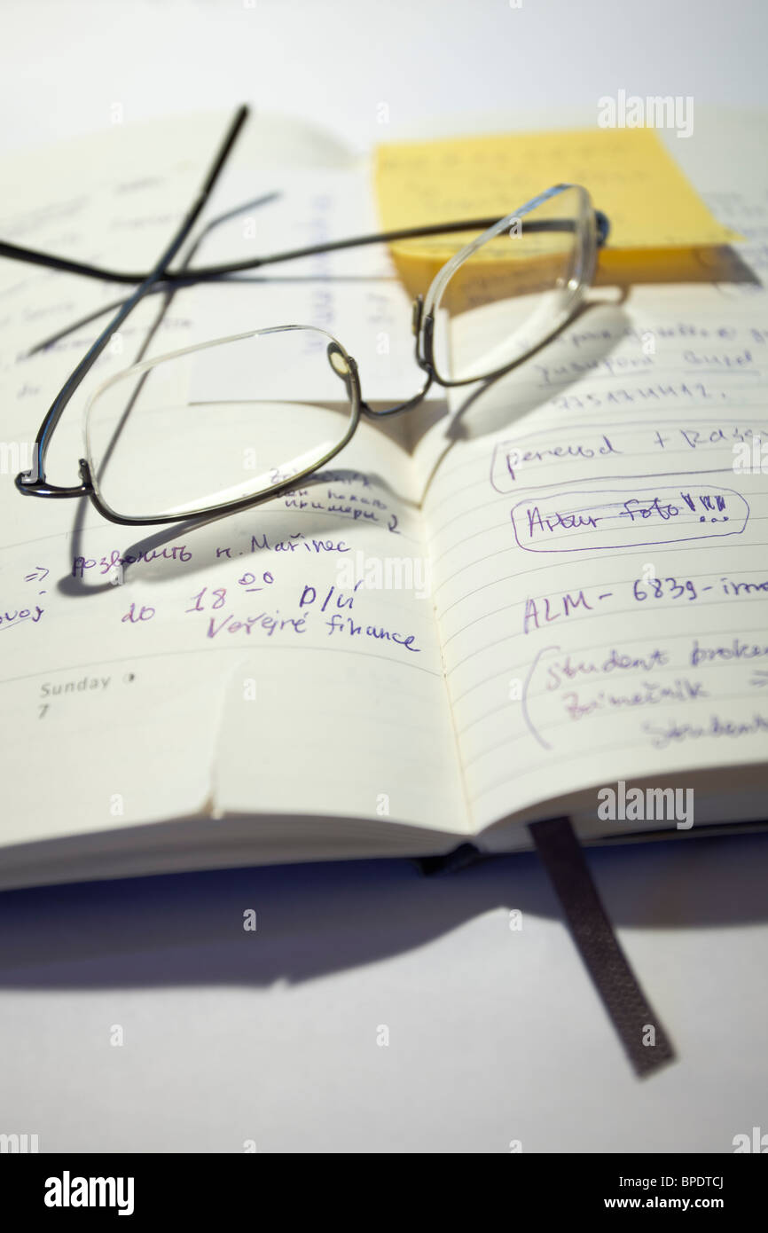 Glasses, on open notebook Stock Photo - Alamy