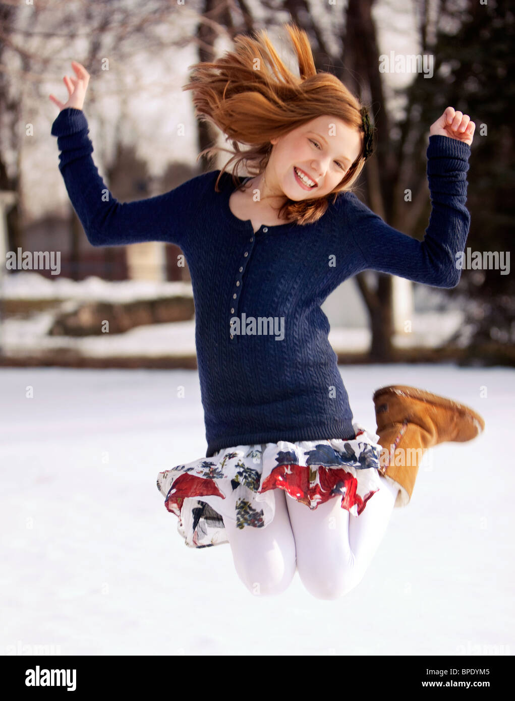 Eleven year-old girl jumping in the snow Stock Photo - Alamy