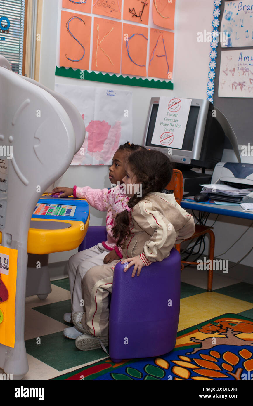 Two 4 year old preschool girls using a computer in the classroom Stock ...