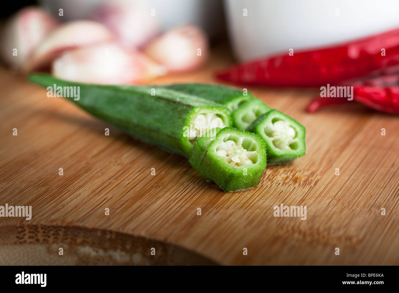 Two okra pods with slices on cutting board Stock Photo - Alamy