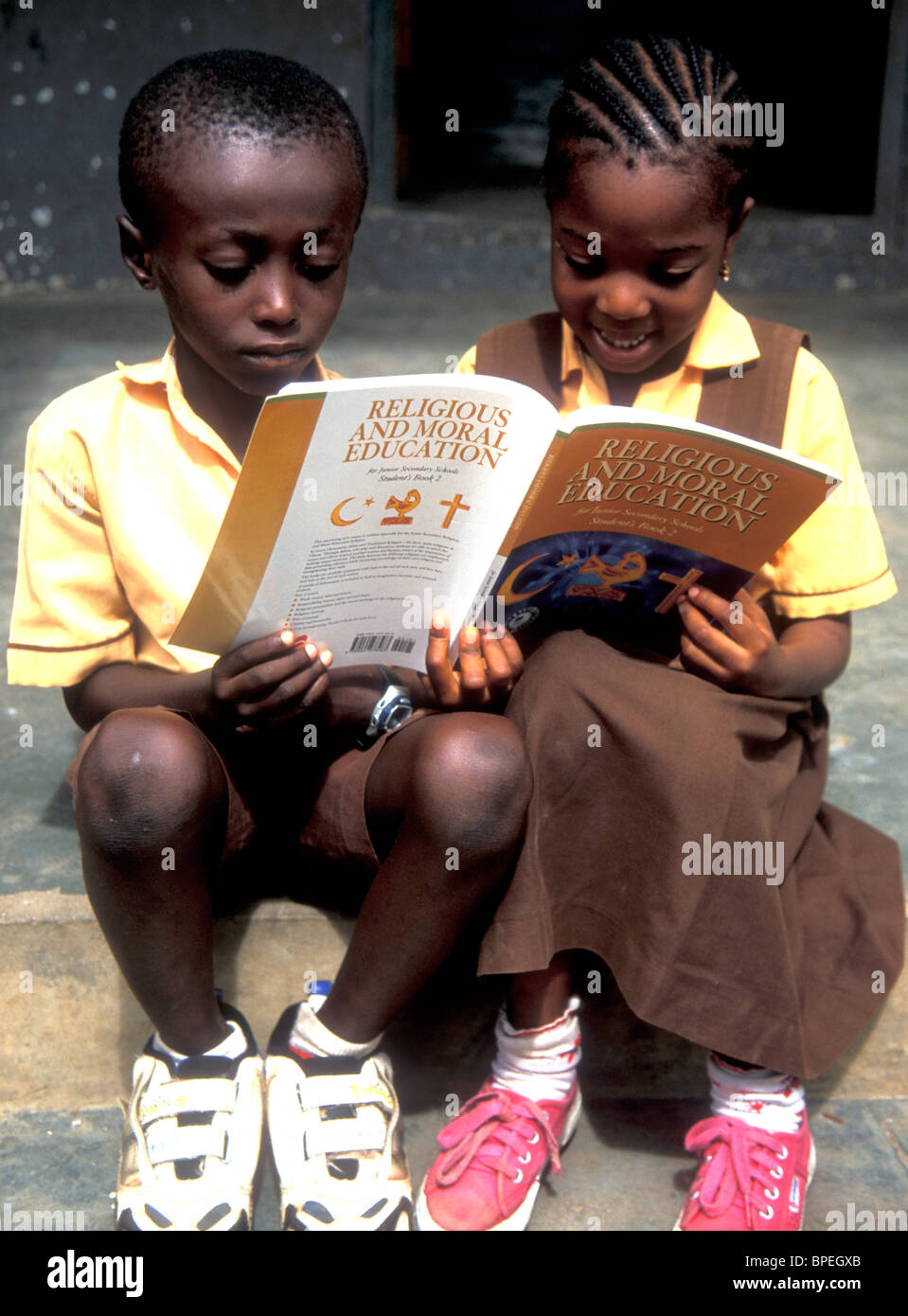 Two schoolchildren reading an education book in Ghana Stock Photo - Alamy