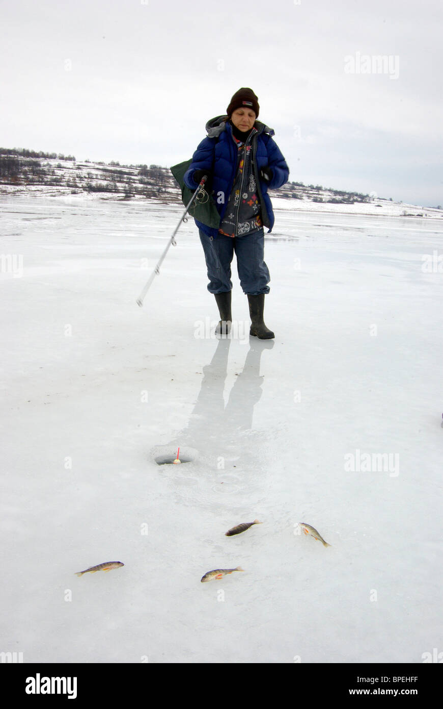 Winter ice fishing in a frozen lake Stock Photo - Alamy