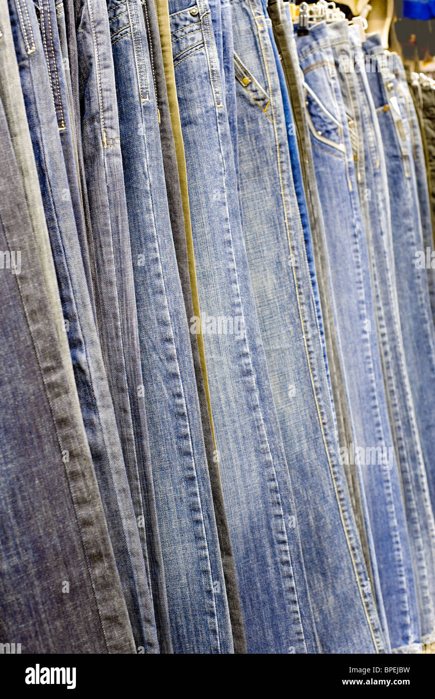line of many jeans hanging in a shop, shallow DOF Stock Photo - Alamy