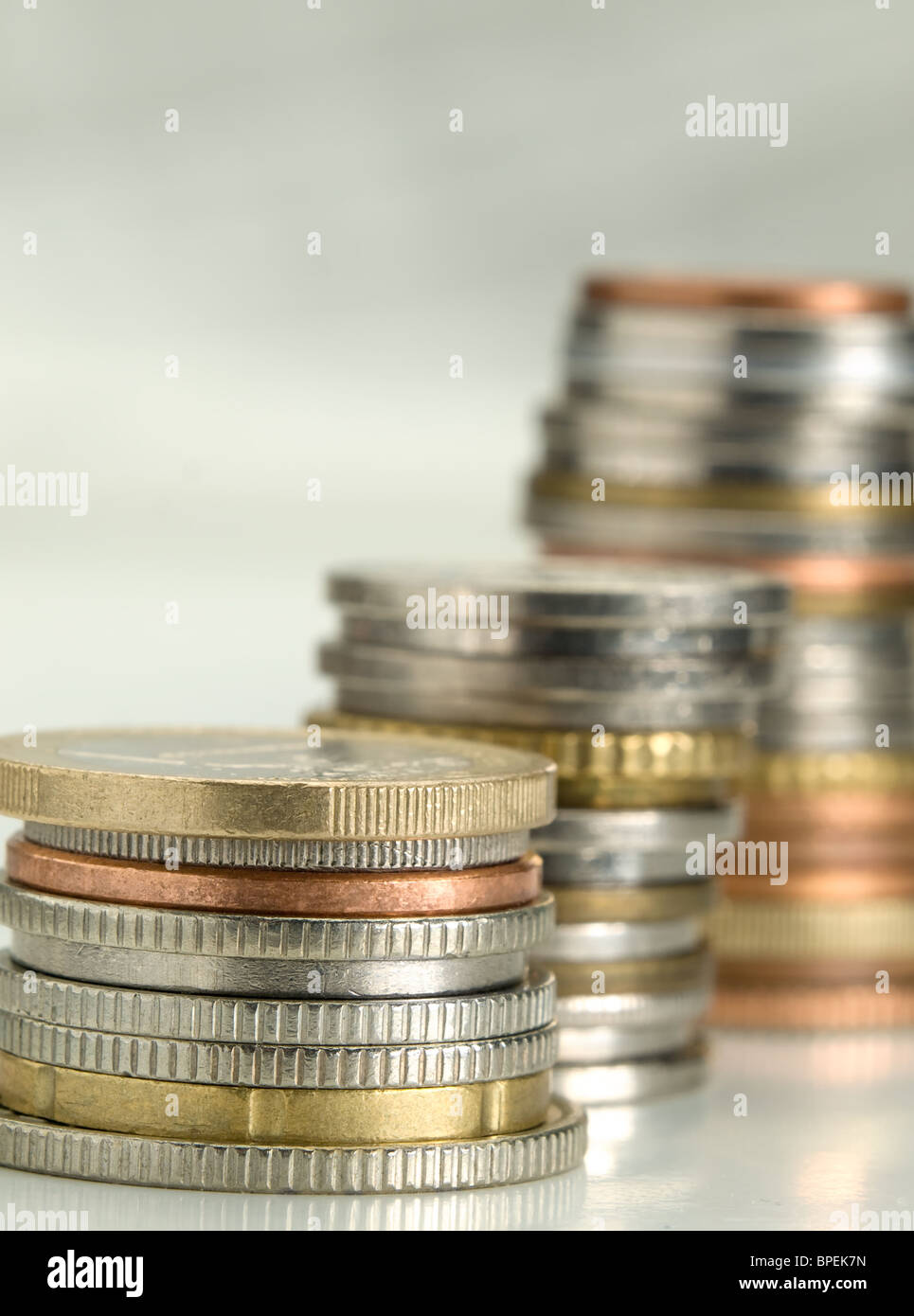 stacks of money coins of various currencies, closeup with shallow DOF ...