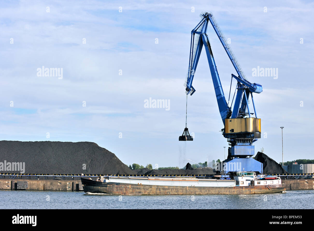 Dock crane loading coal / ore in inland vessel at Ghent seaport ...