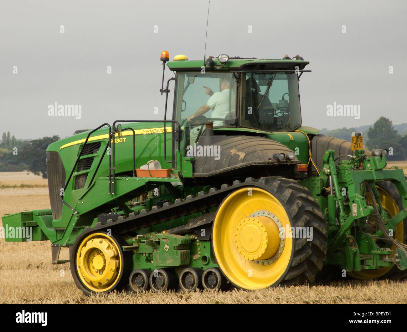 John Deere rubber tracked tractor working in a recently harvested corn ...