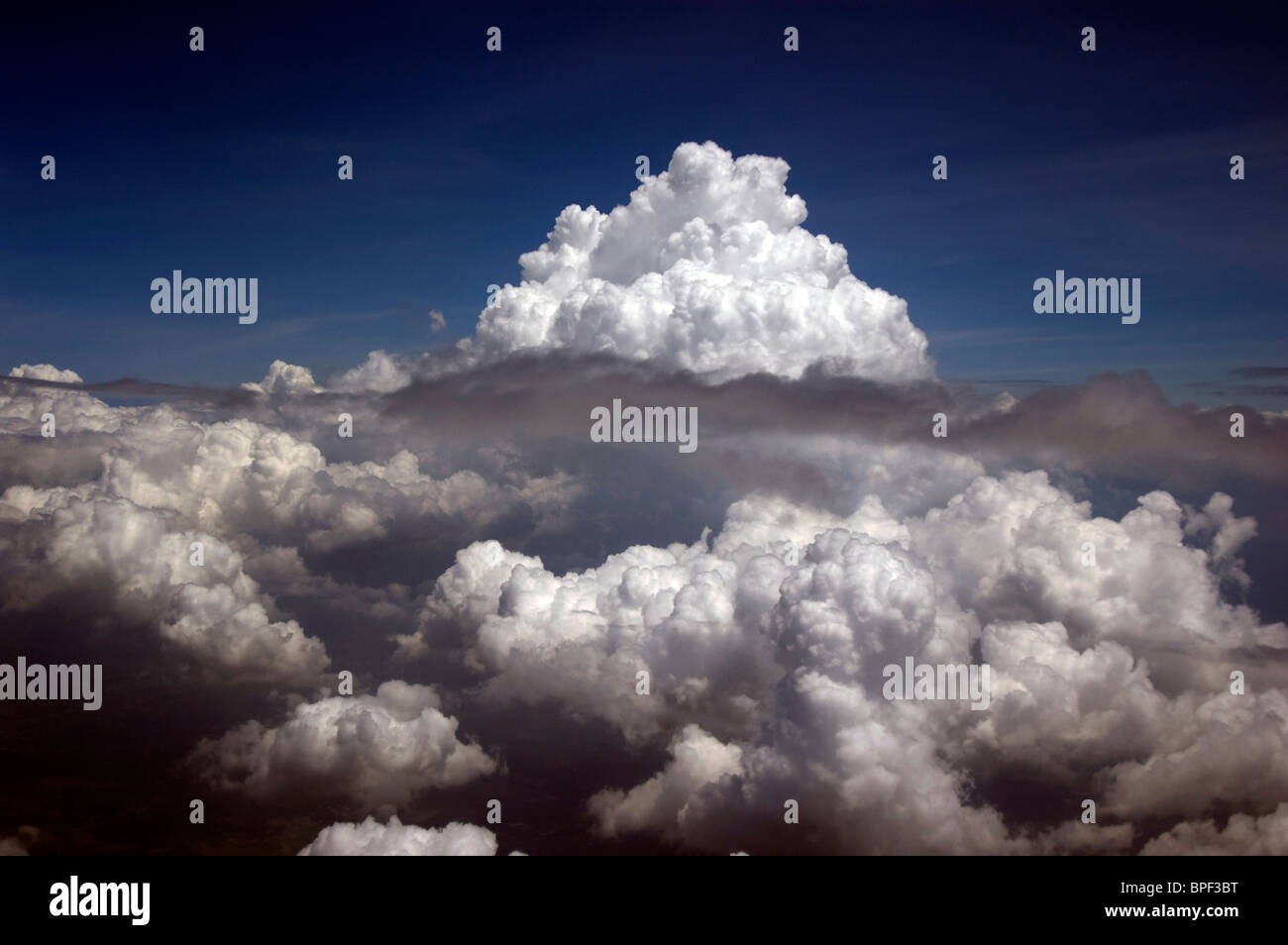 Bright white storm cloud rises above rain cloud Stock Photo - Alamy