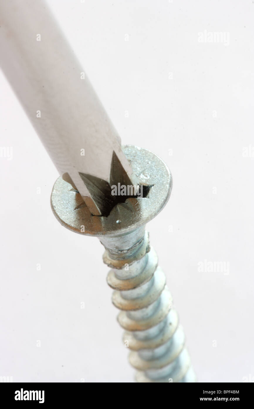 Screwdriver and screw over white background Stock Photo - Alamy