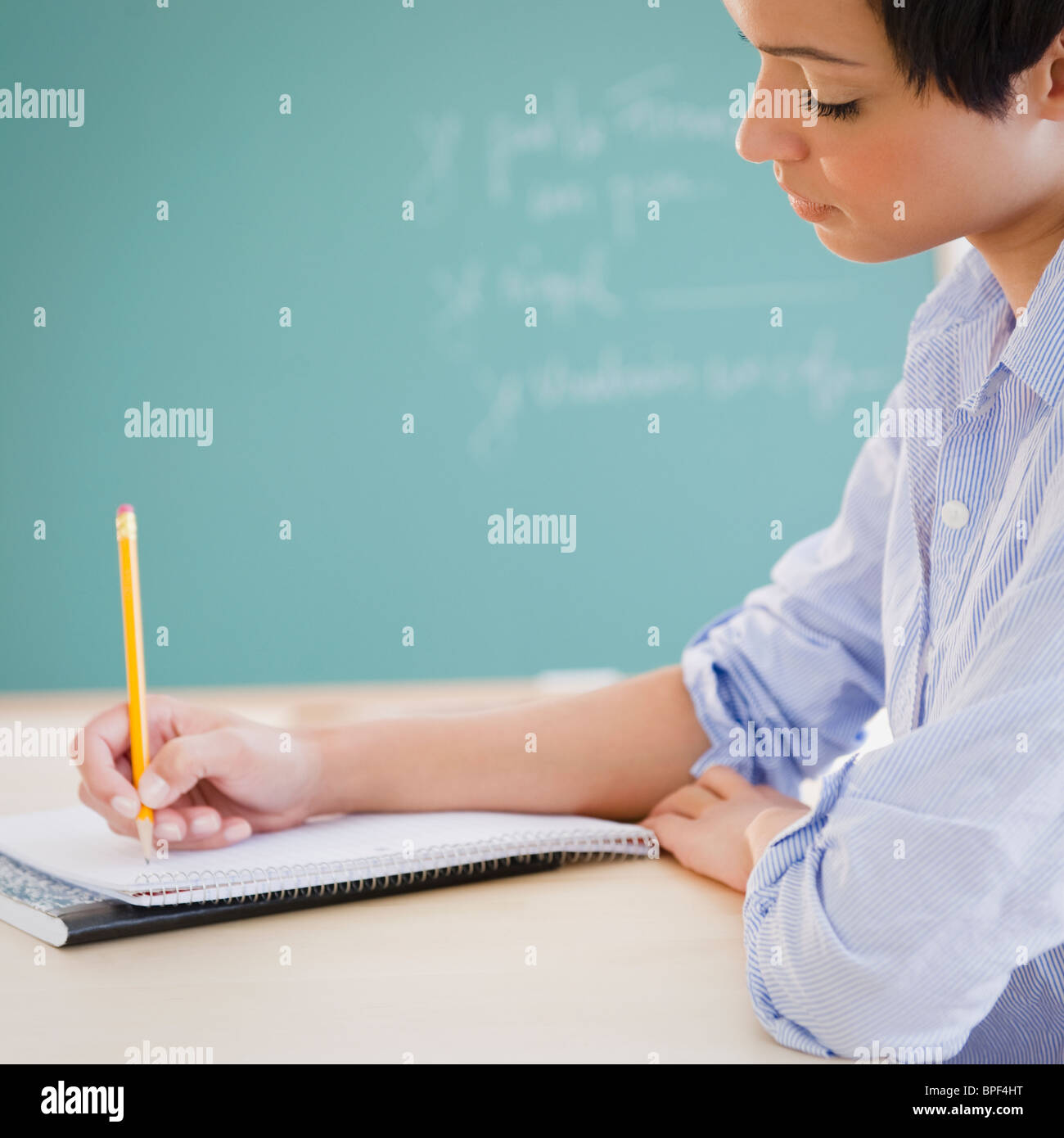 Mixed race woman writing in notebook Stock Photo - Alamy